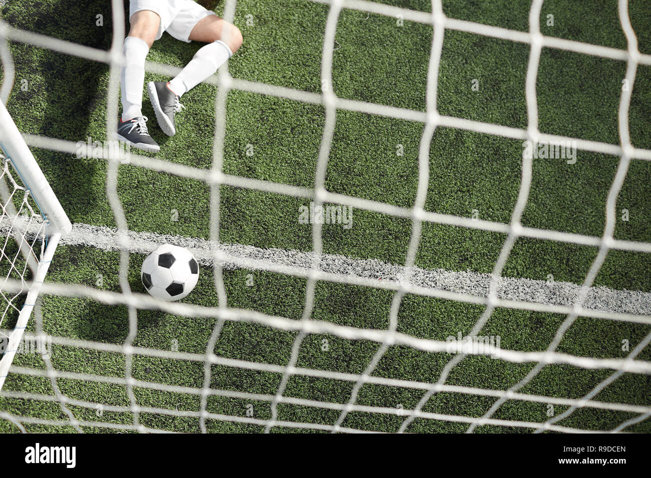 Ball in gate and goalkeeper Stock Photo - Alamy