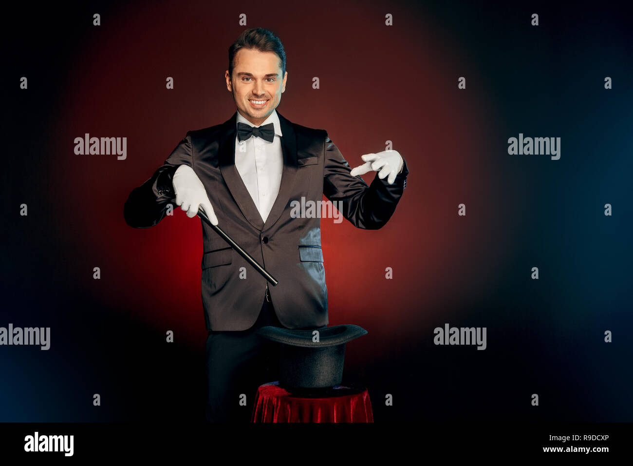Professional magician wearing suit and gloves standing isolated on ...