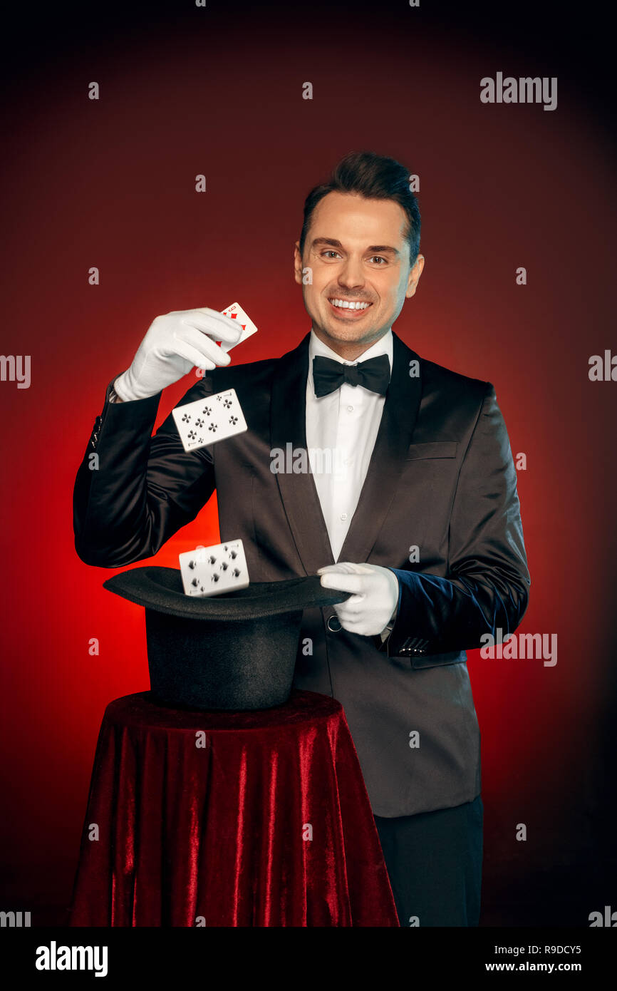 Professional magician wearing suit and gloves standing isolated on ...