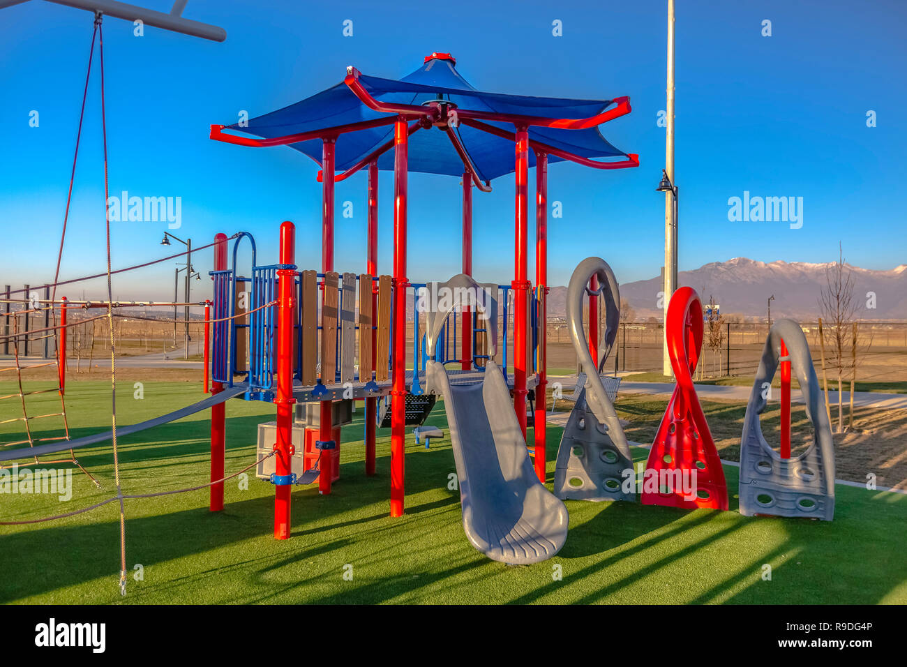 Umbrella and shade over slide on playground Stock Photo - Alamy