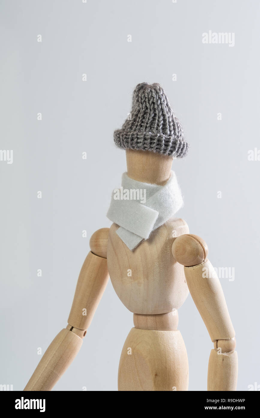 a wooden puppet with scarf and cap sitting on a decorated ...