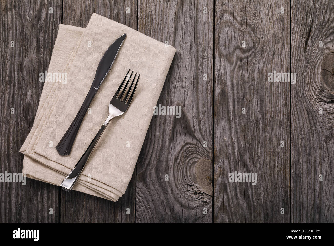 Cutlery and napkin on a wooden table with copy space, top view. Food ...