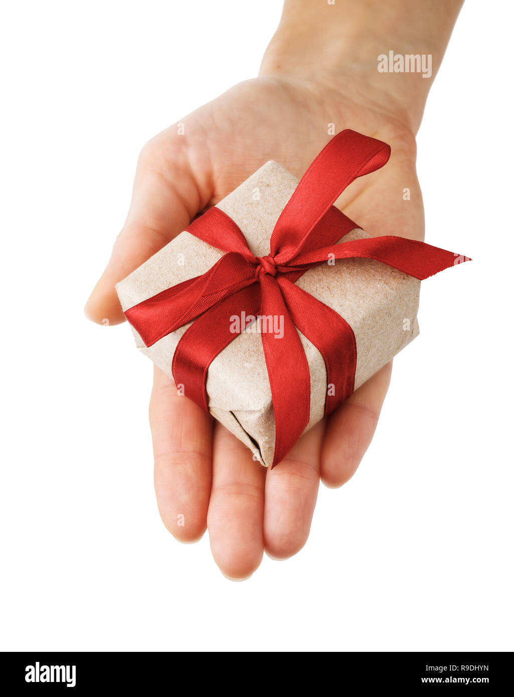 Gift tied with a red ribbon in hand closeup isolated on white ...