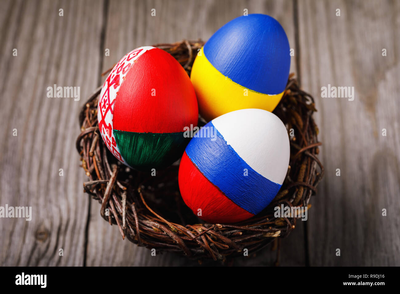 Three Easter eggs painted in colors of the flags of Ukraine, Belarus ...