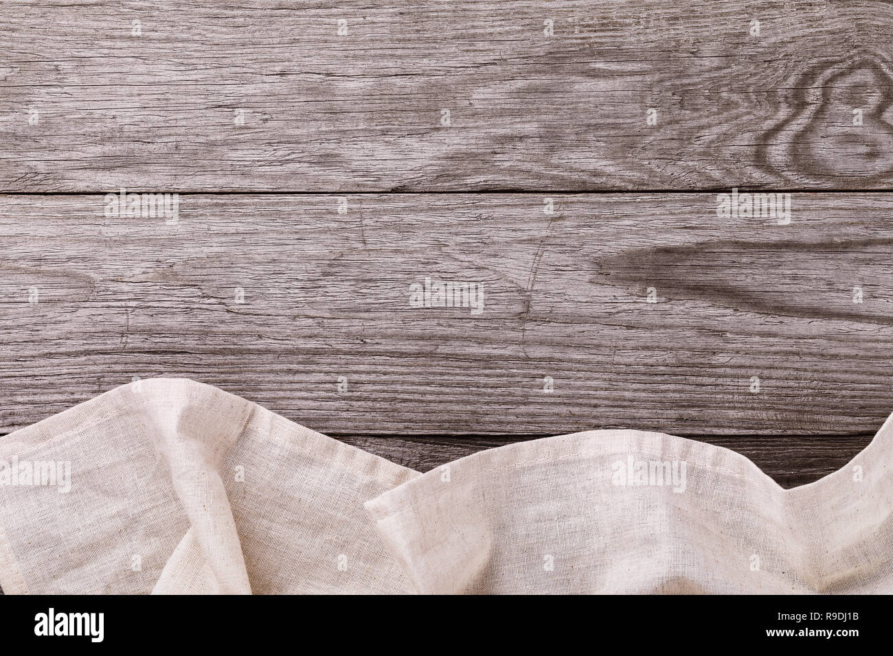 Top view of a gray tablecloth at the bottom of a wooden table. Food ...