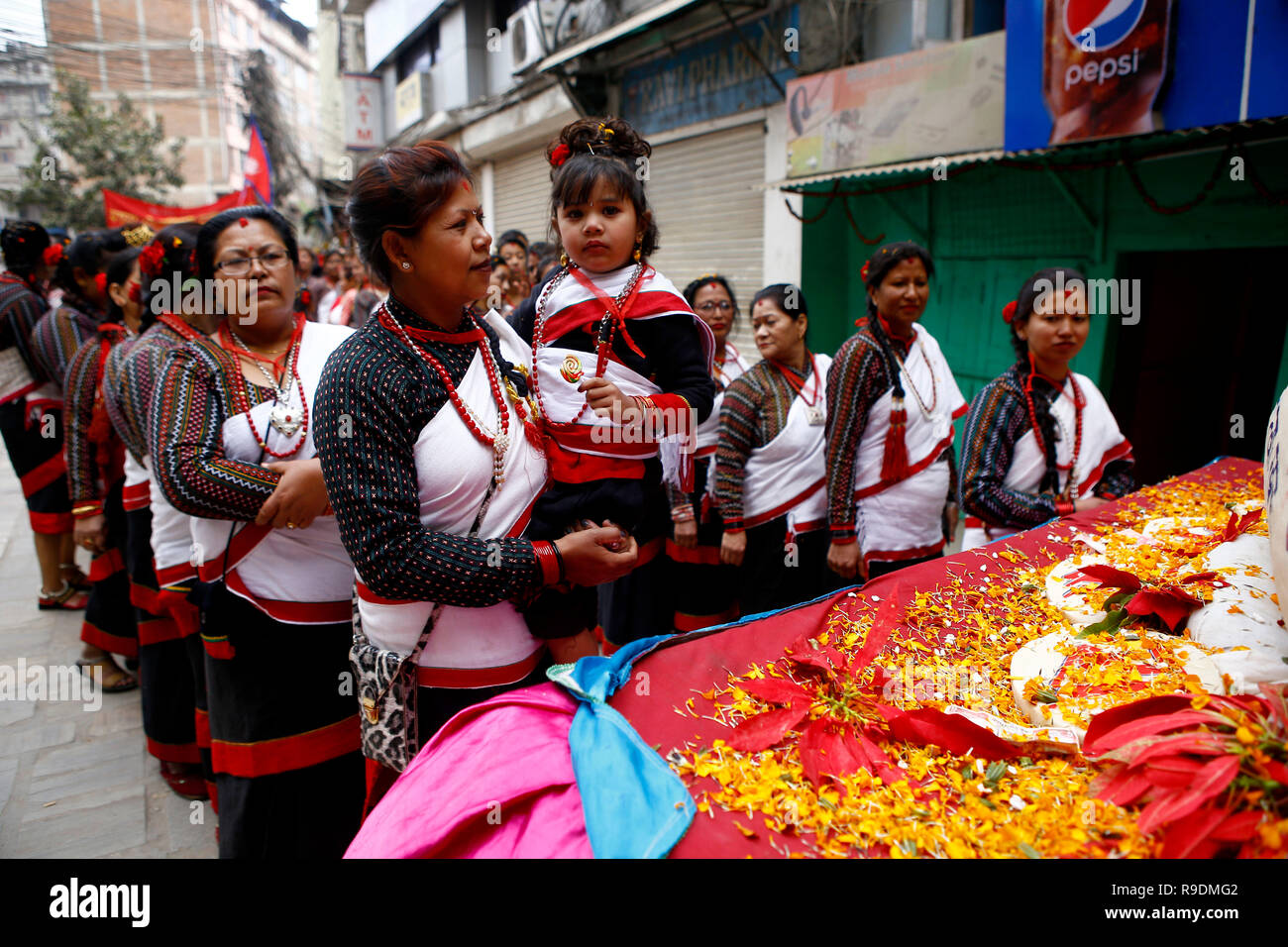 A woman from Newar community seen in traditional attire carrying a kid ...