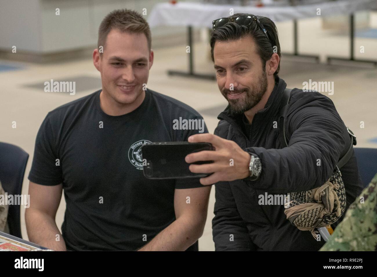 Manama, Bahrain. 21st Dec, 2018. Actor Milo Ventimiglia, right, takes a ...