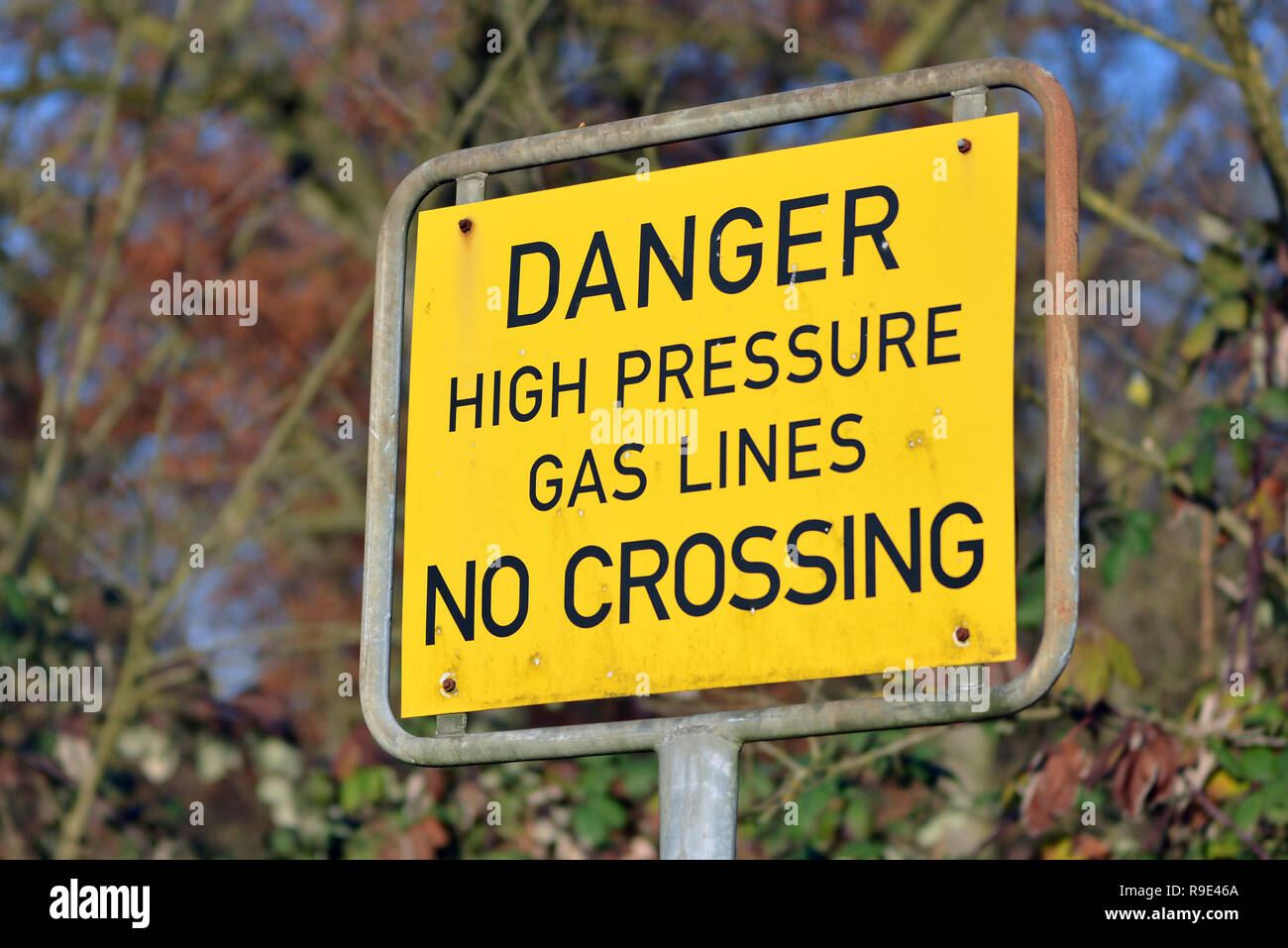 Close up of a yellow outdoor warning sign saying dager high pressure ...