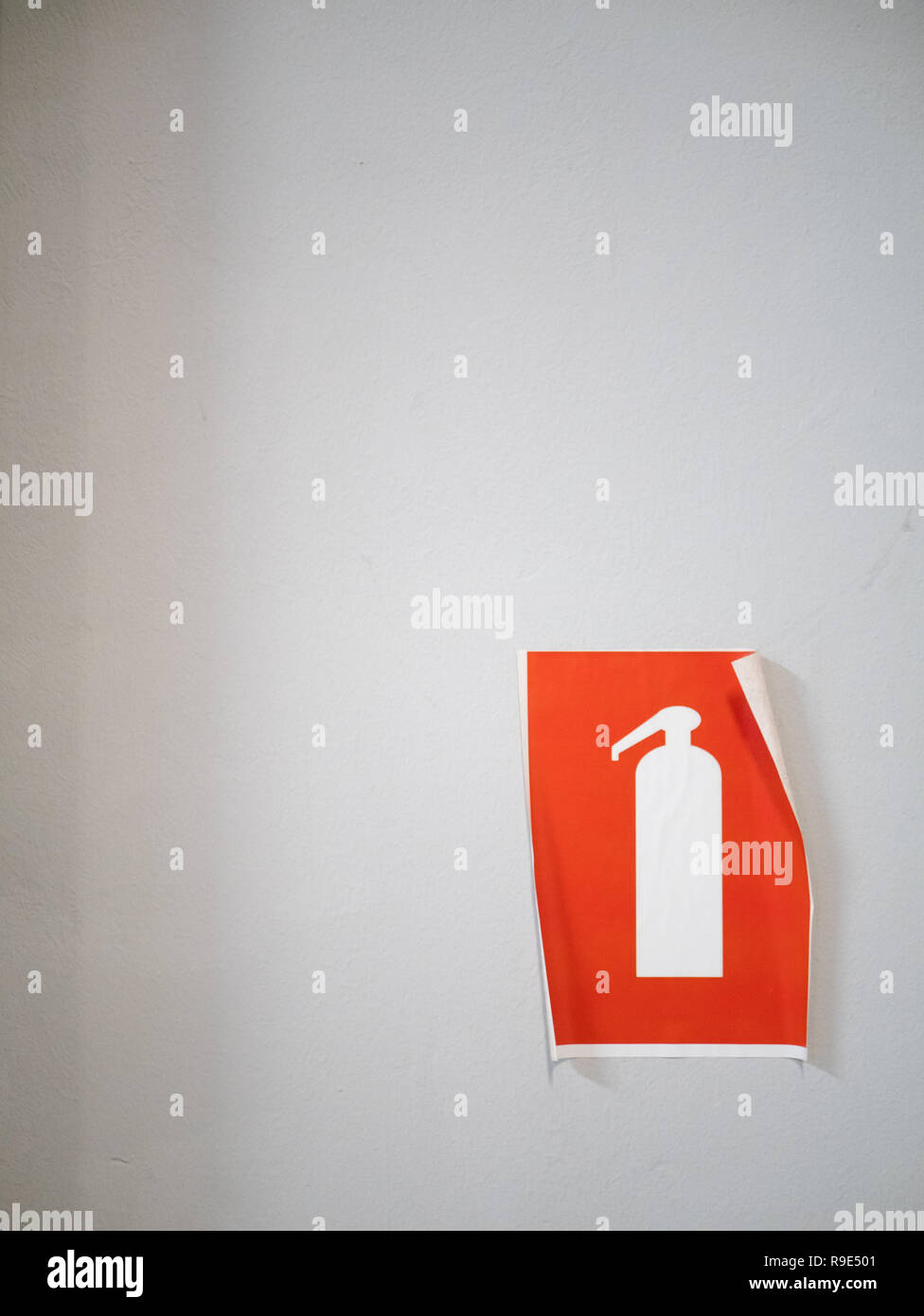 peeling off orange fire extinguisher sign sticker on white light wall ...