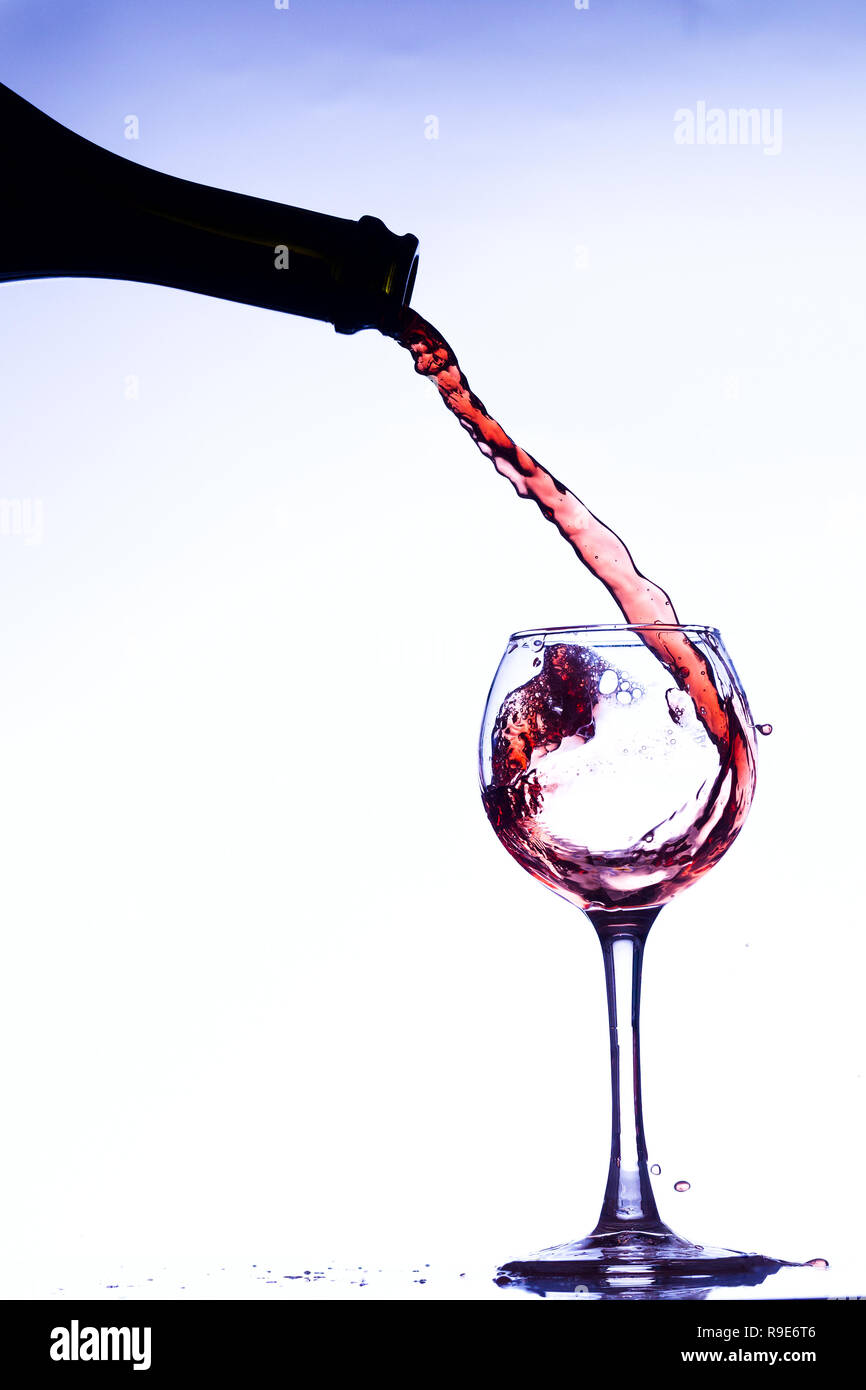 Wine pouring from a bottle into a glass, studio lighting Stock Photo ...