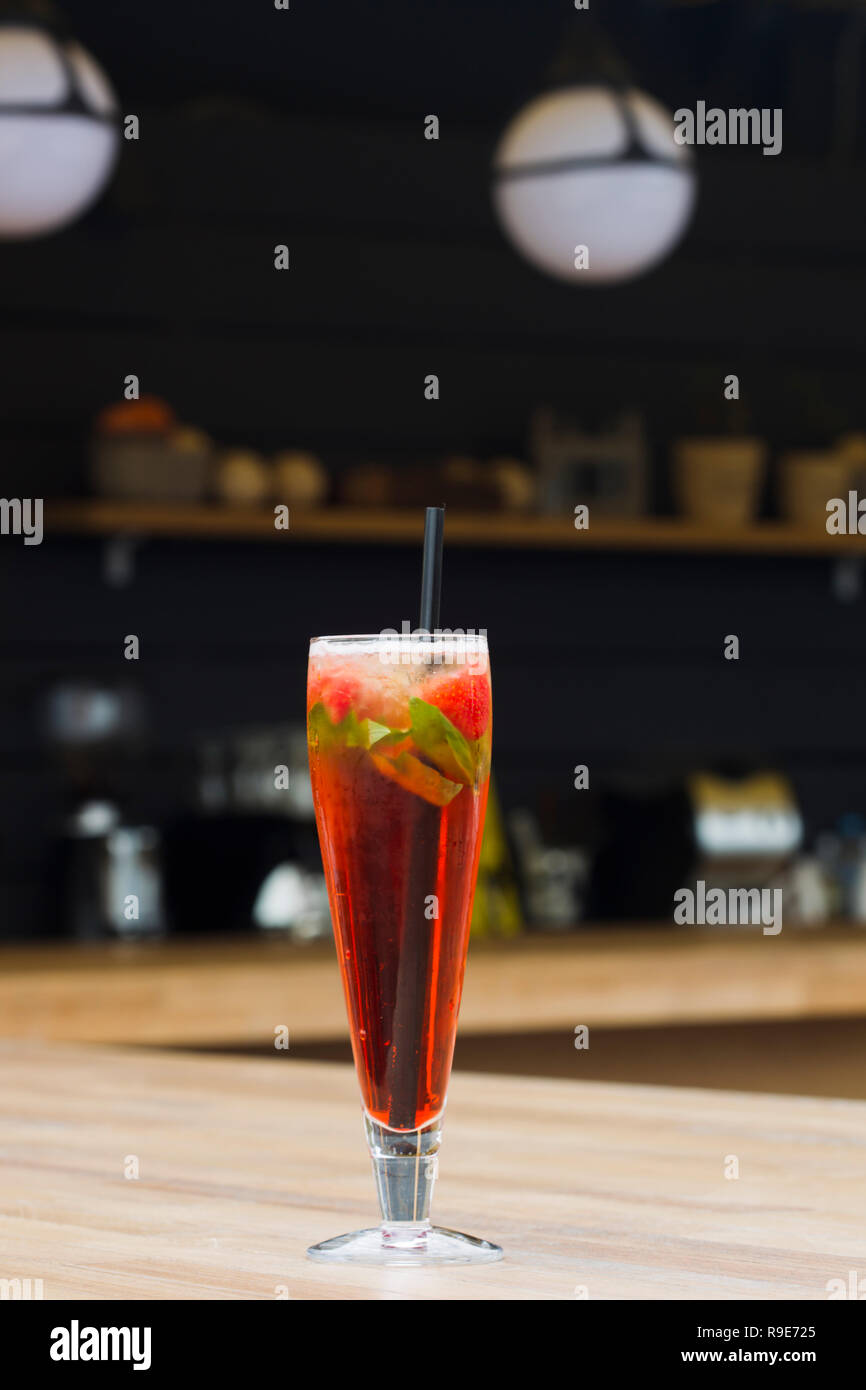 Cold lemonade with strawberries, mint and ice on the outdoor veranda ...