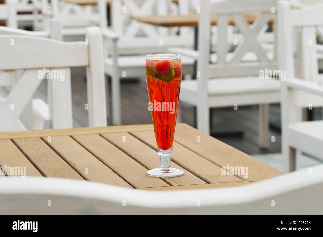 Cold lemonade with strawberries, mint and ice on the outdoor veranda ...
