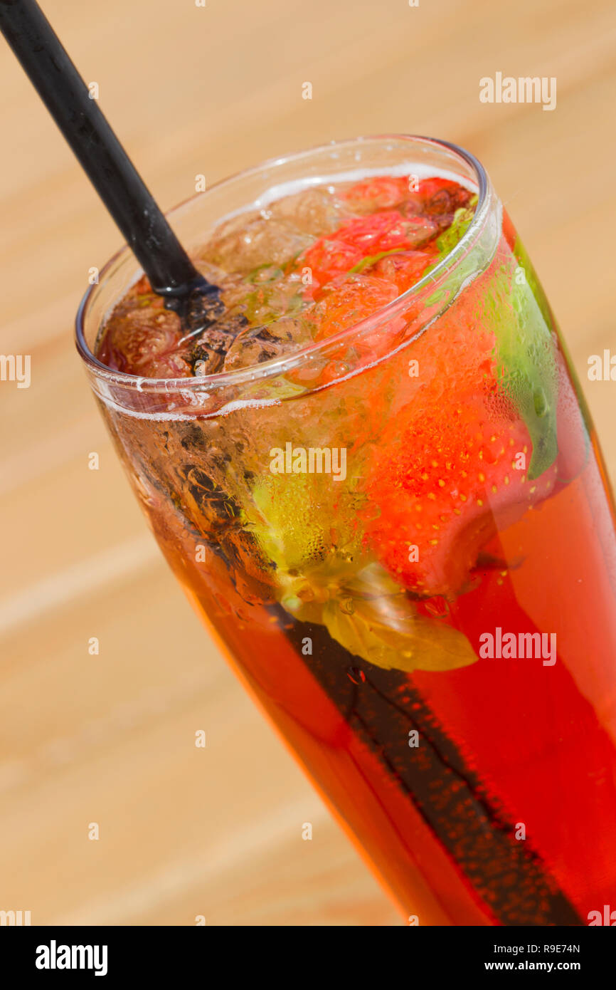 Cold lemonade with strawberries, mint and ice on the outdoor veranda ...