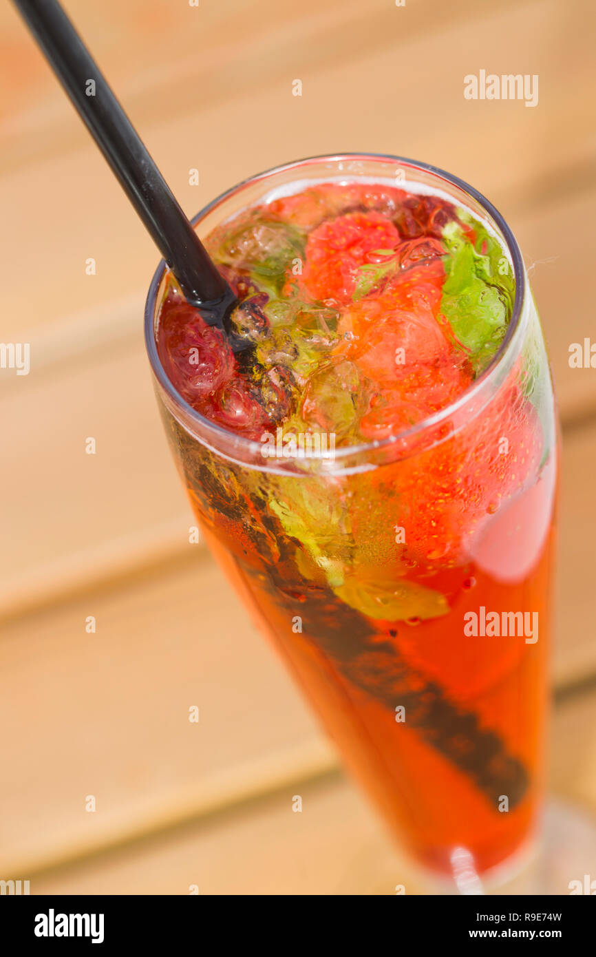 Cold lemonade with strawberries, mint and ice on the outdoor veranda ...
