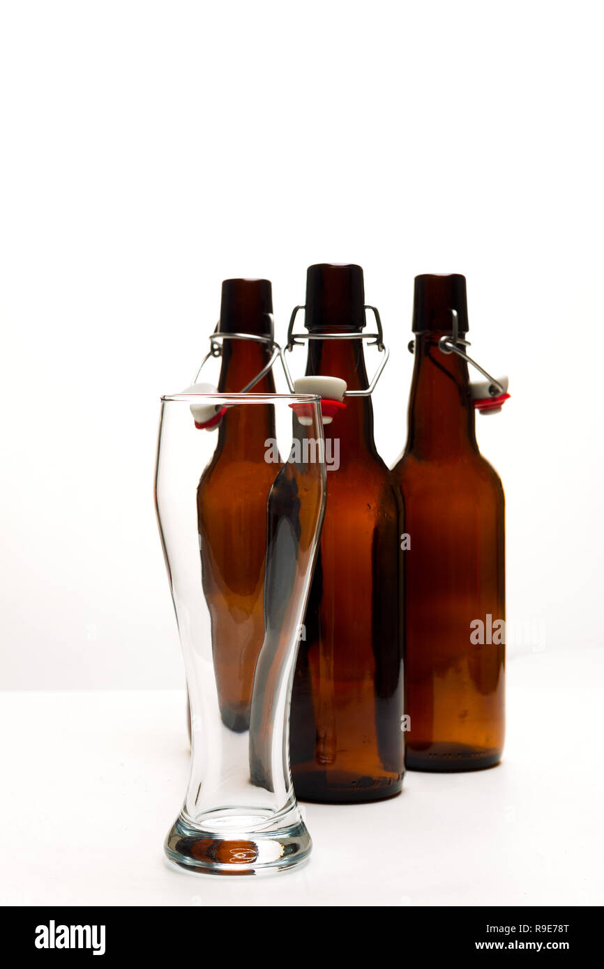 Empty beer glass and empty beer bottles on a white background, studio ...