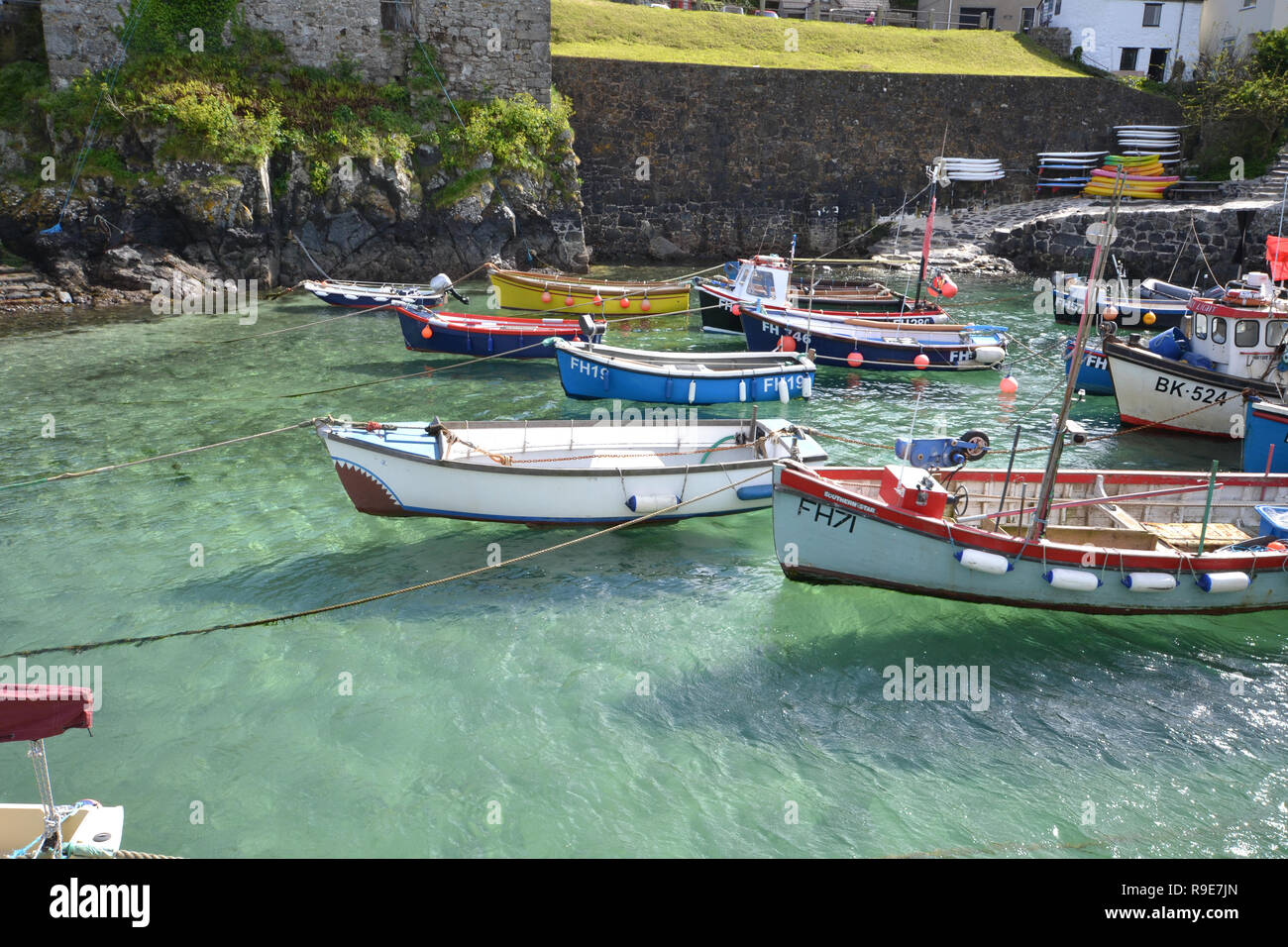 Moored boats in the clear water at Coverack Harbour in Cornwall Stock ...