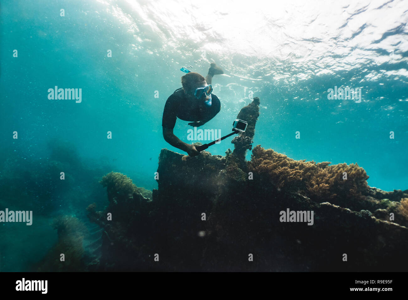 Freediver shooting on cam coral reef with fish near wreckship Stock ...