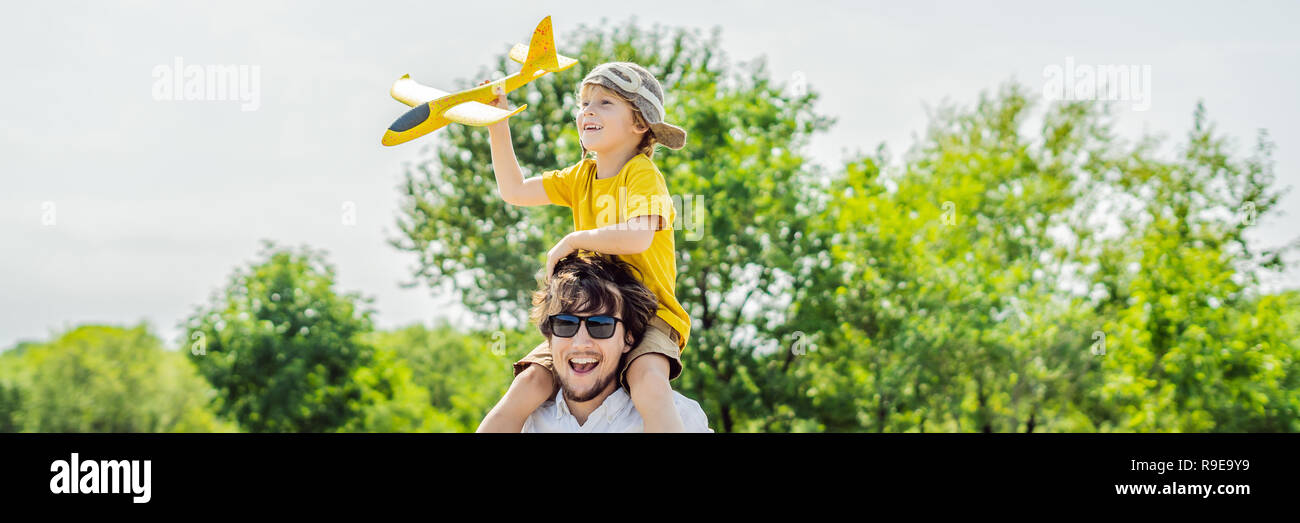 Happy father and son playing with toy airplane against old runway ...