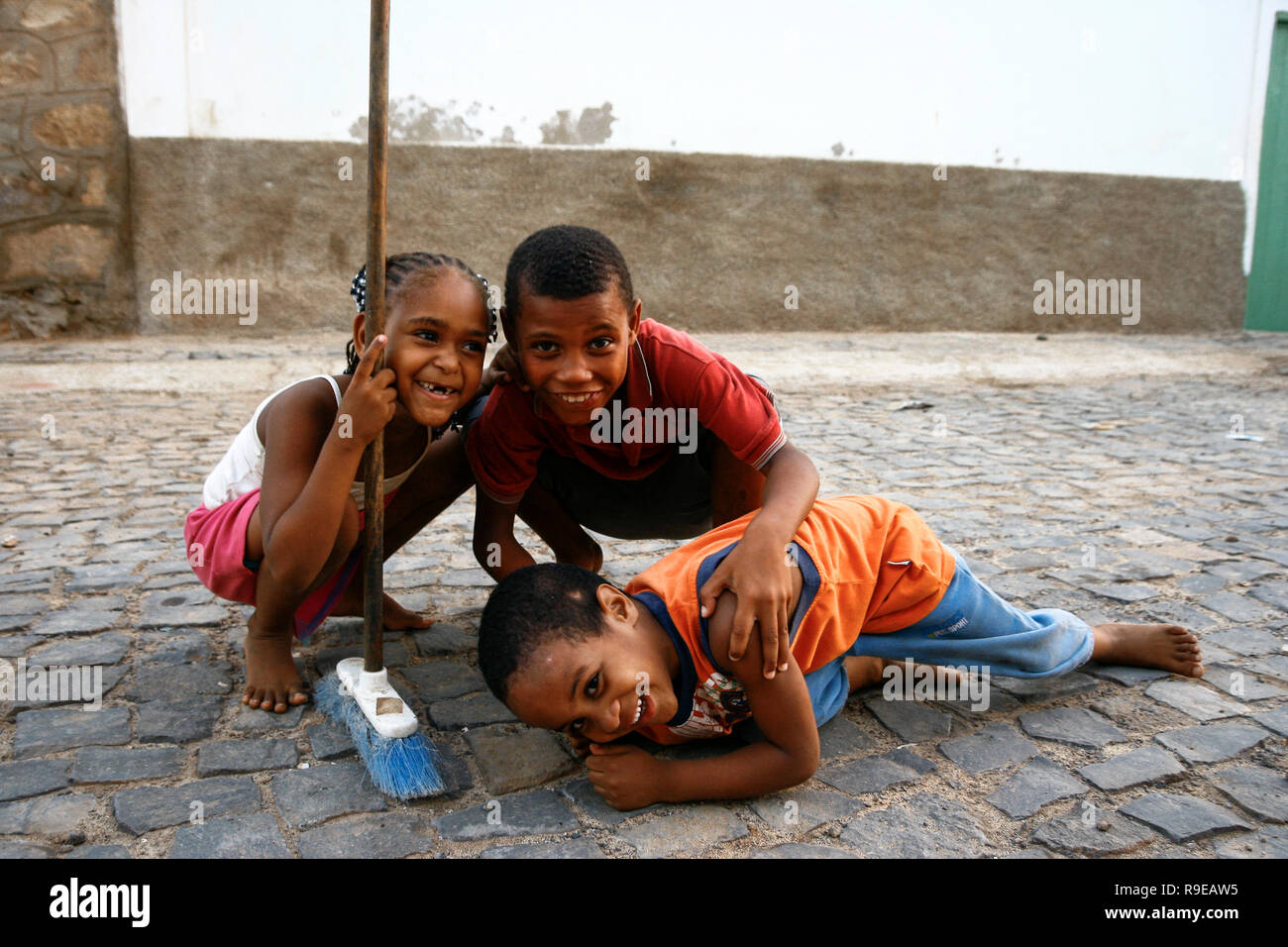 Three kids playing outside Stock Photo - Alamy