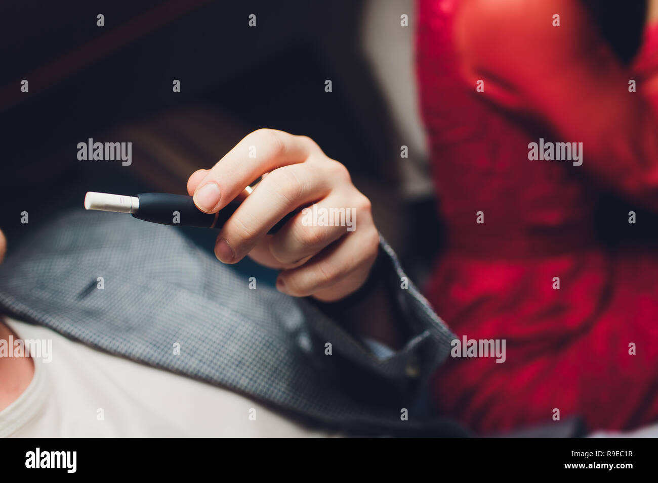 IQOS heat-not-burn tobacco product technology. Man holding e-cigarette ...