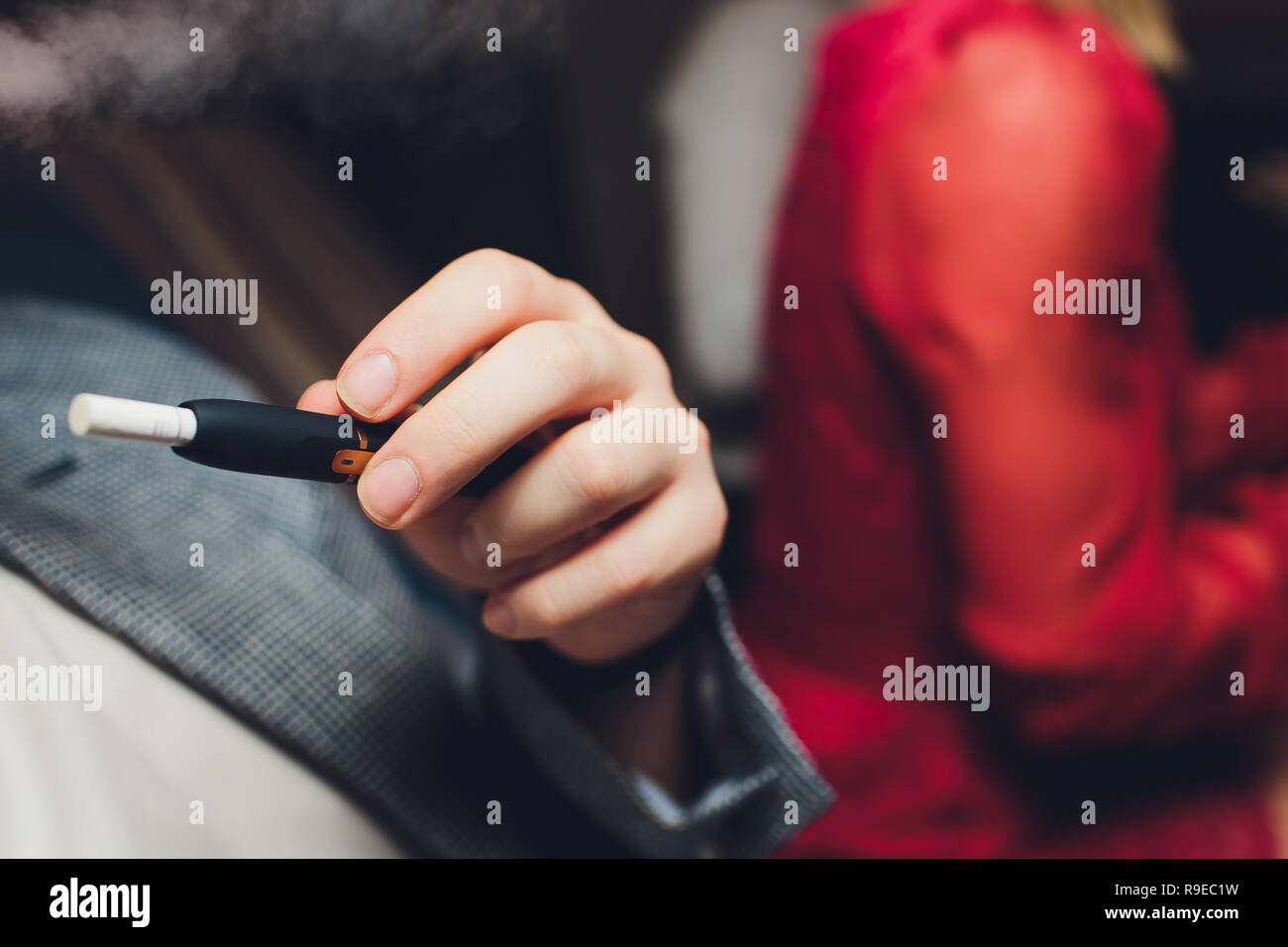 IQOS heat-not-burn tobacco product technology. Man holding e-cigarette ...