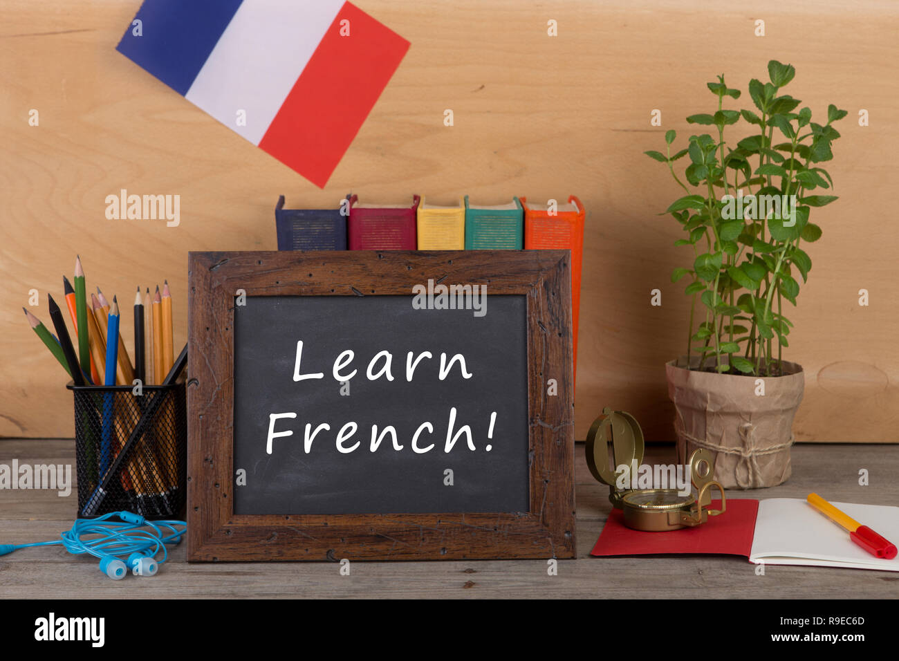 Learning languages concept - blackboard with text "Learn French!", flag ...