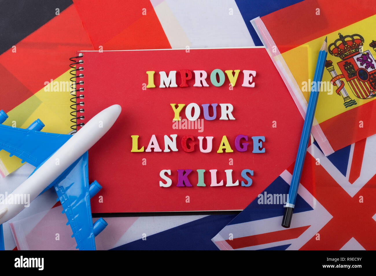 Learning languages concept - red notepad and colorful wooden letters ...