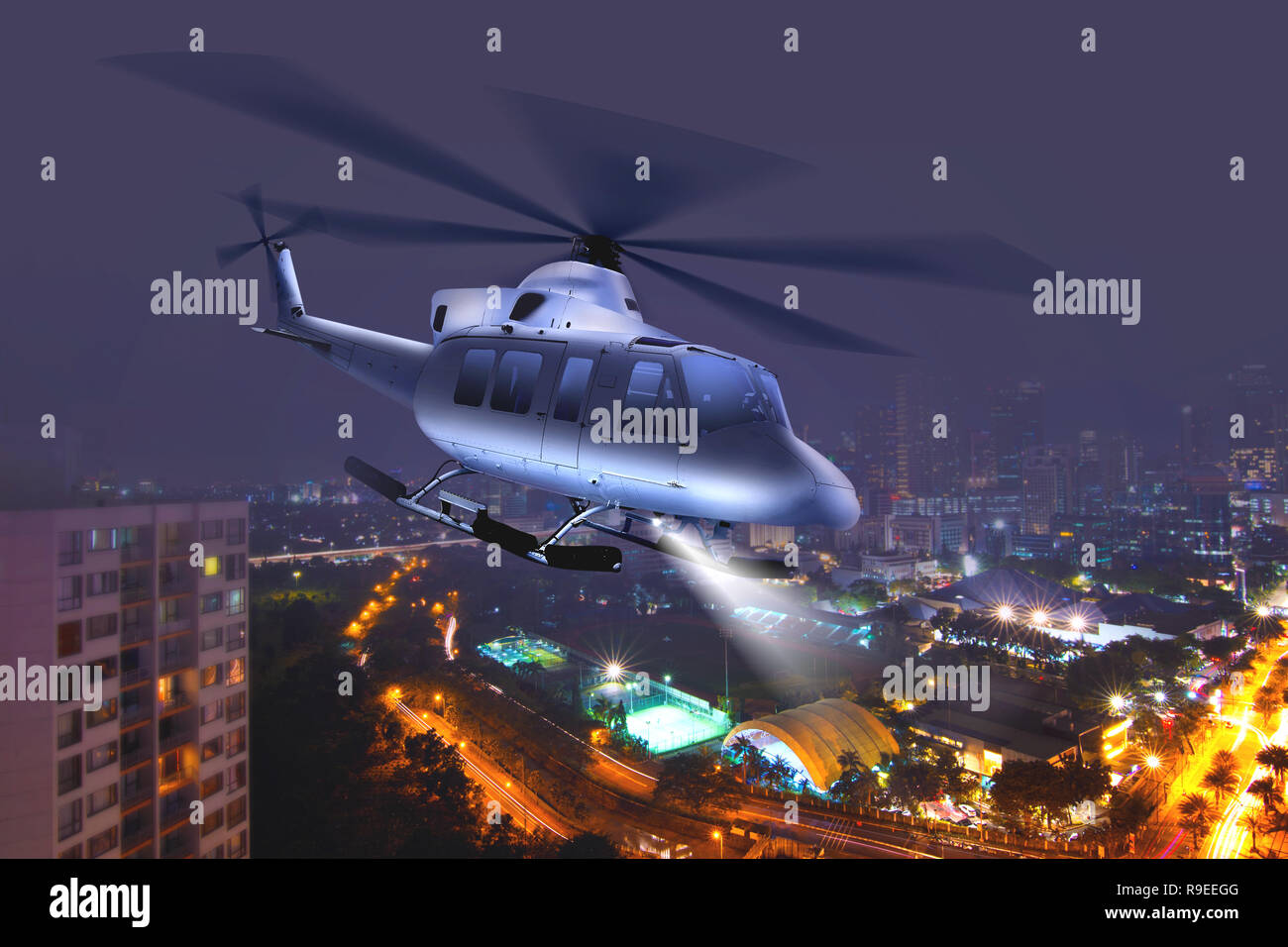 Helicopter flying over the city at night Stock Photo - Alamy