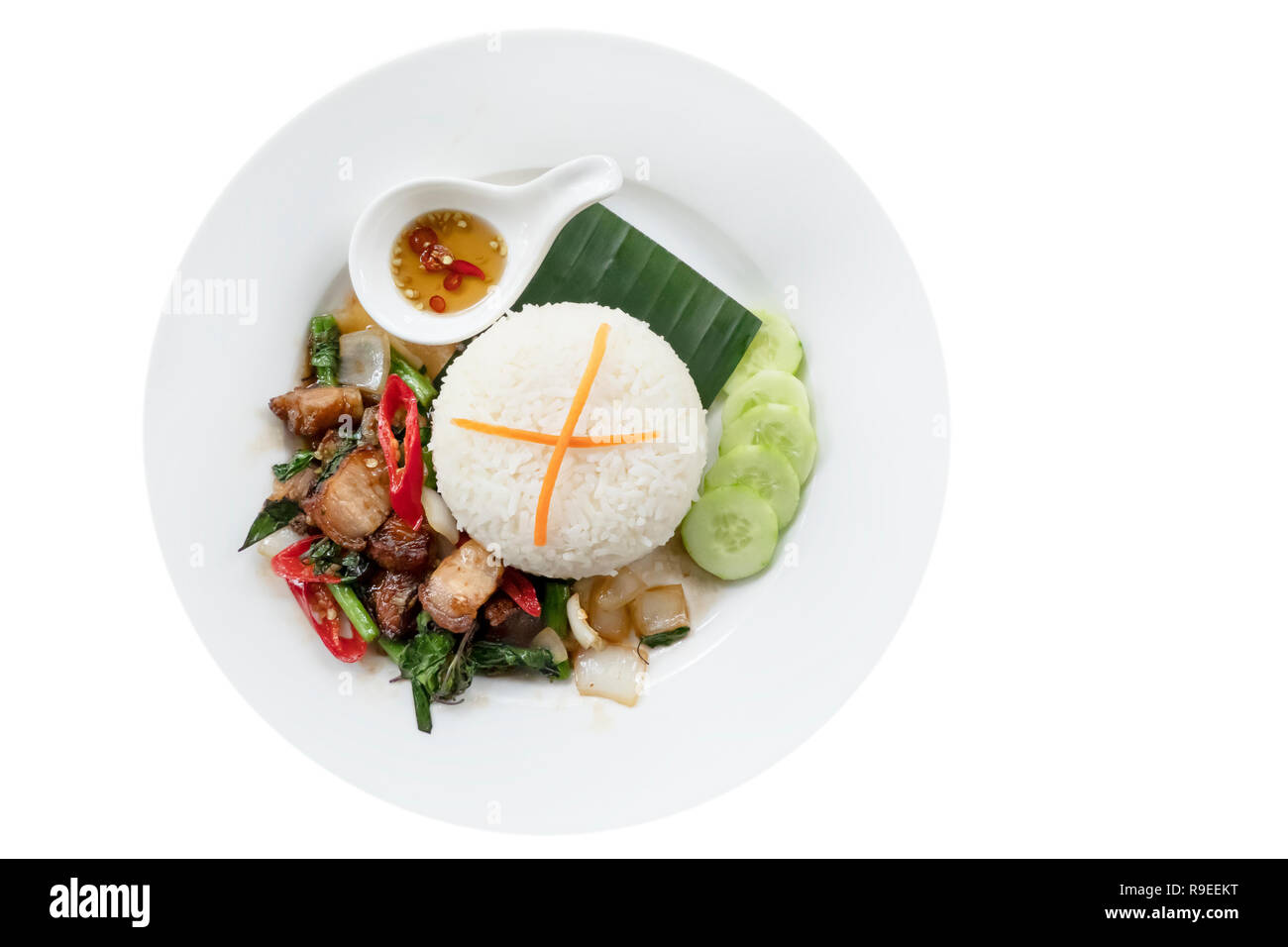 Stir fried crispy pork and mixed vegetable served with rice on dish ...