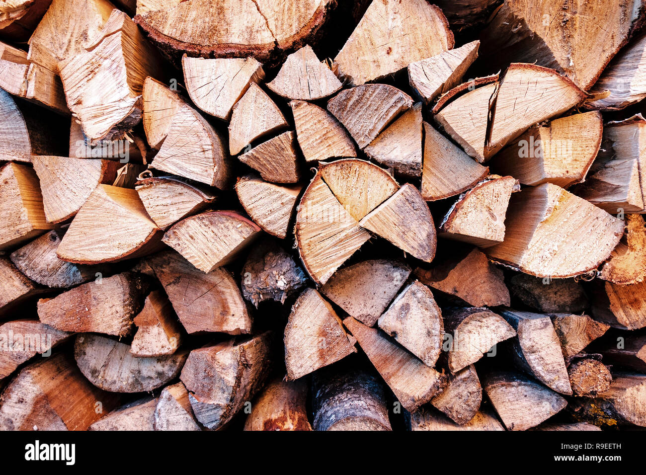 Background texture of chopped wood or logs end on in a stack for winter ...