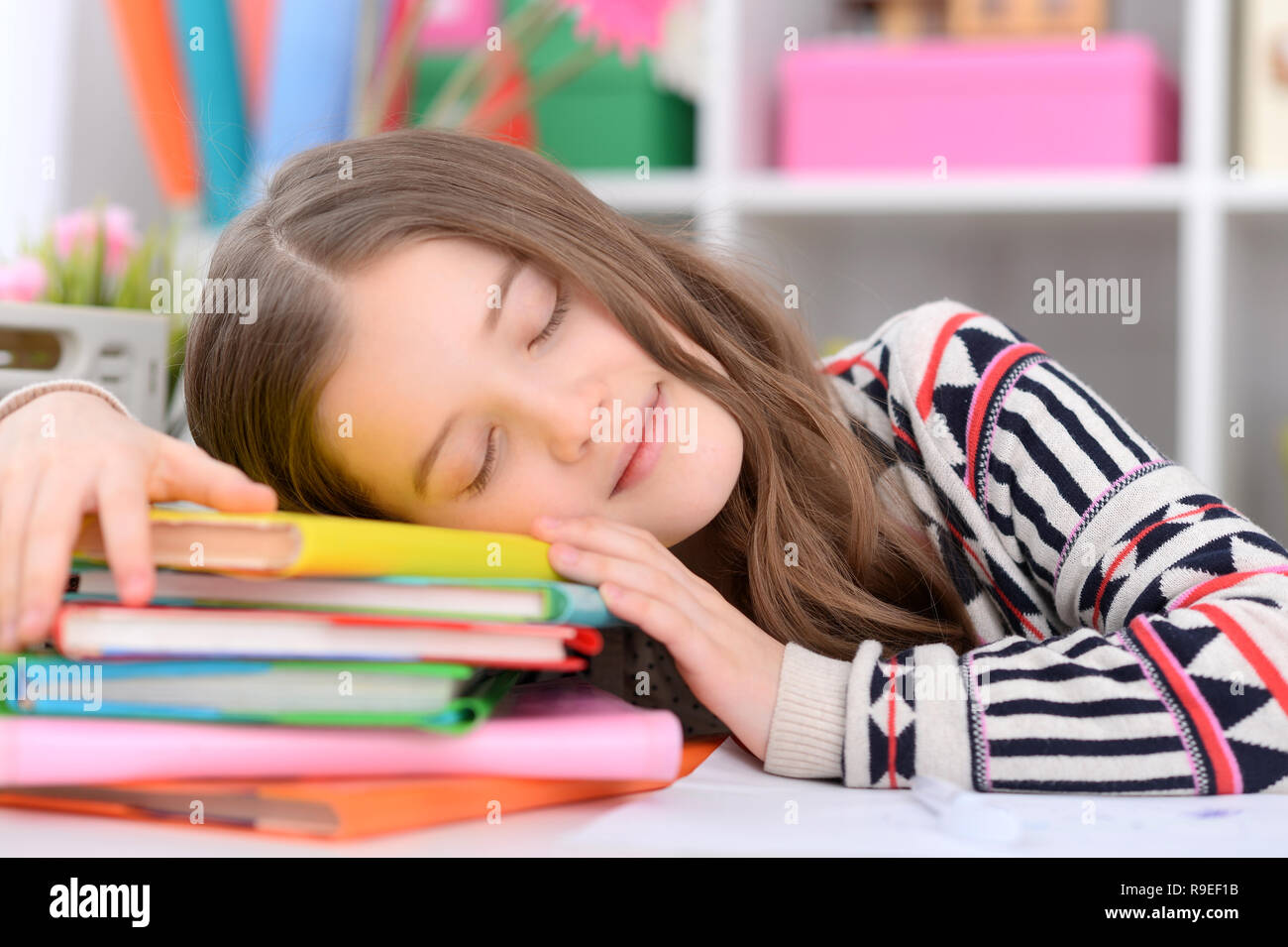 Cute schoolgirl sleeping on table after doing homework at home Stock ...