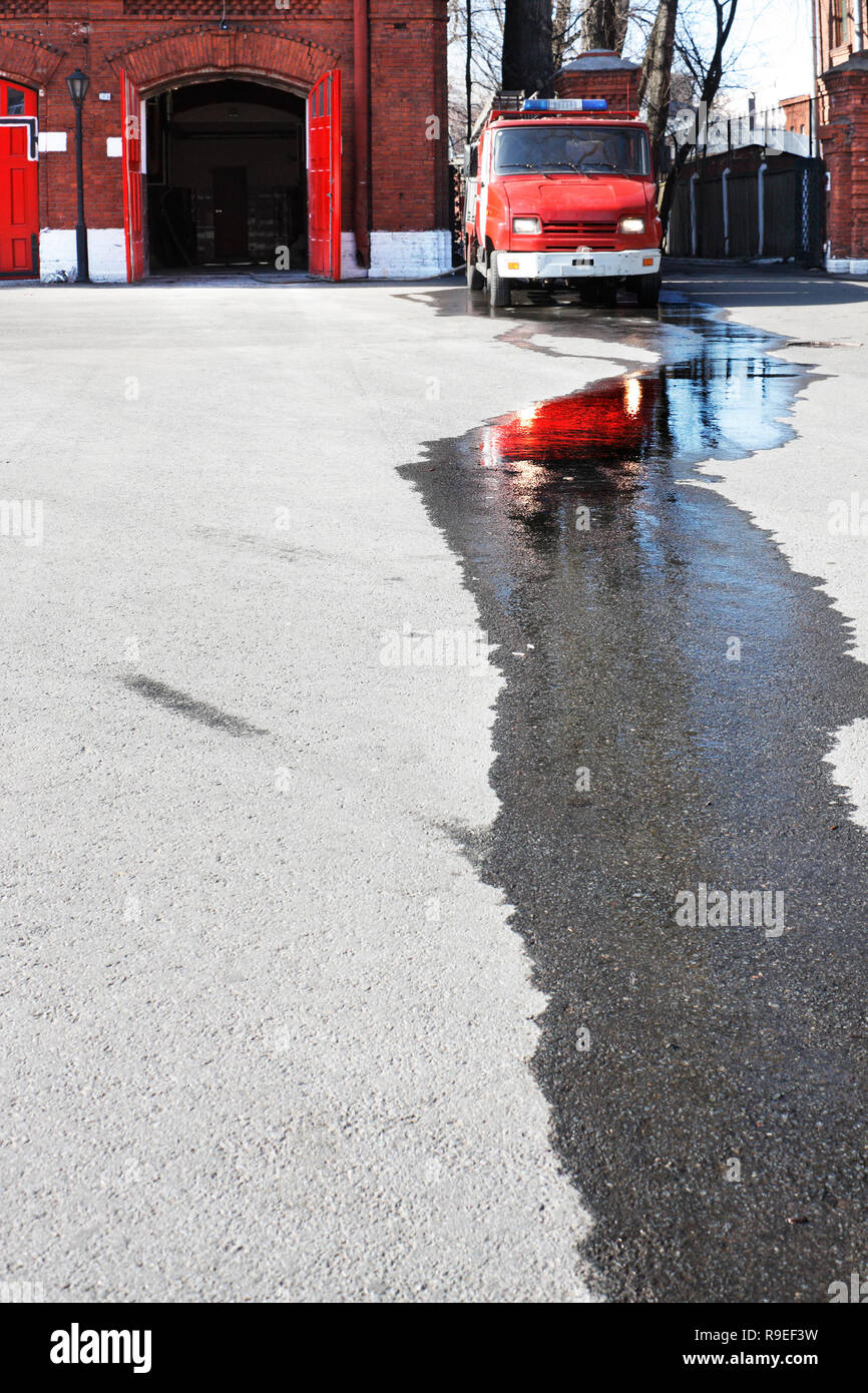 Fire engine and a water puddle at the firehouse Stock Photo - Alamy