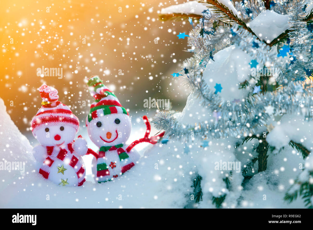 Two small funny toys baby snowman in knitted hats and scarves in deep ...