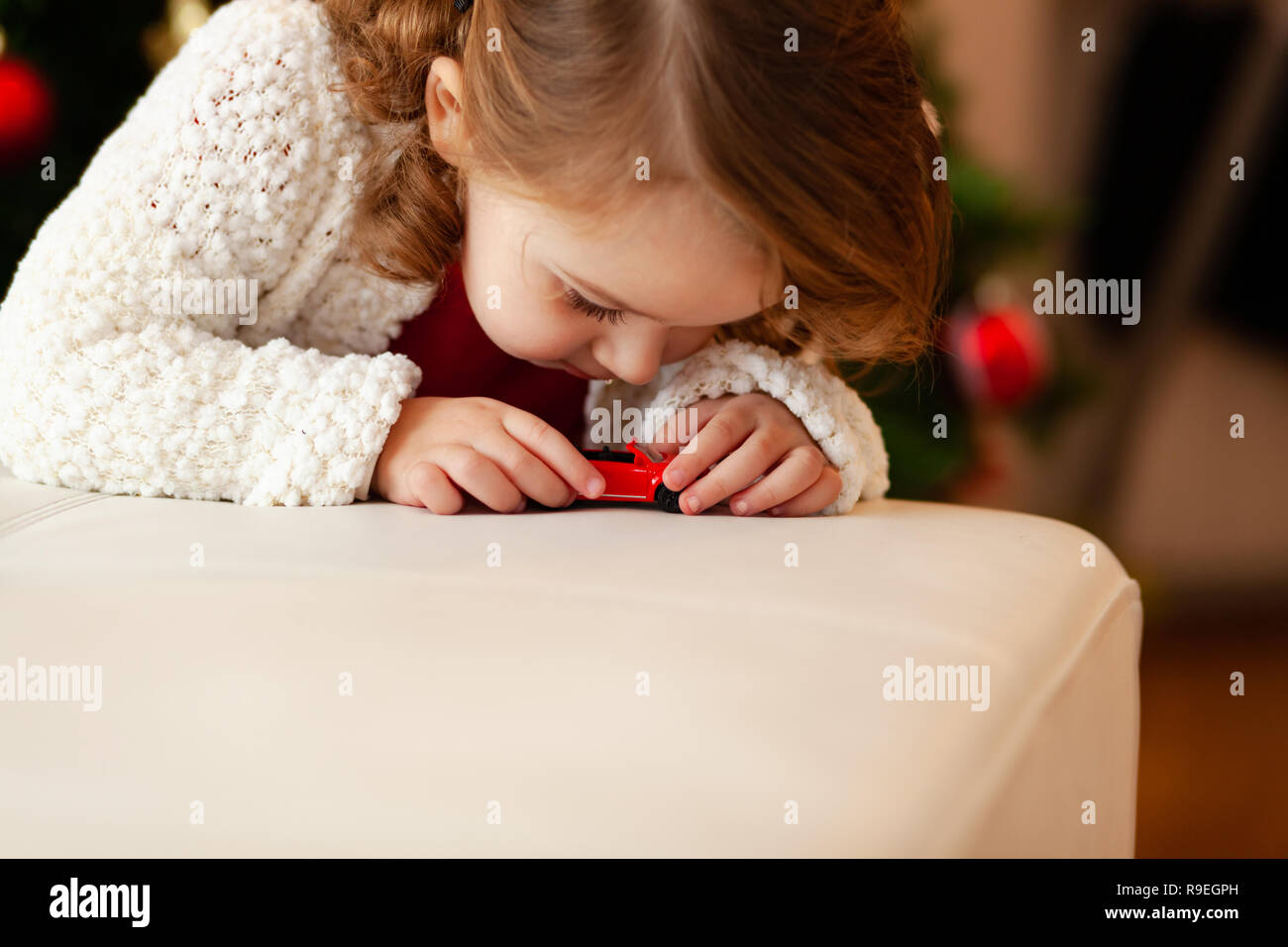Beautiful little child plays with little red toy car Stock Photo - Alamy