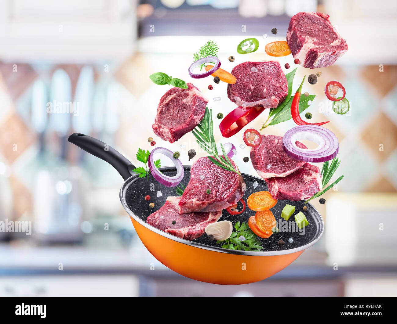 Flying meat steaks and spices falling into a frying pan. Flying motion ...