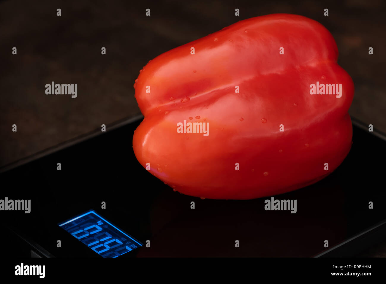 Red pepper is on an electronic weight on a black background Stock Photo ...