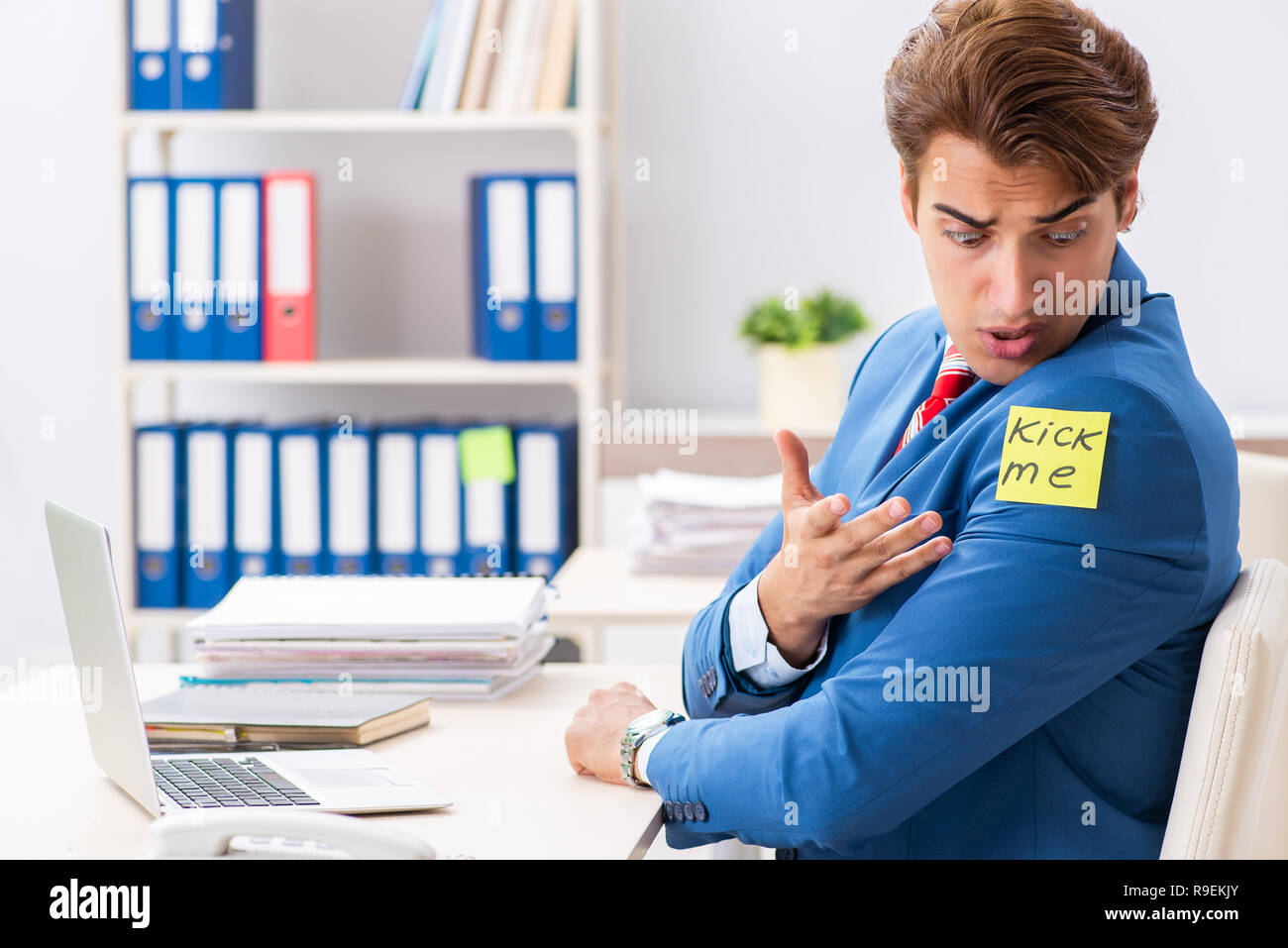 Office prank with kick me message on sticky note Stock Photo - Alamy