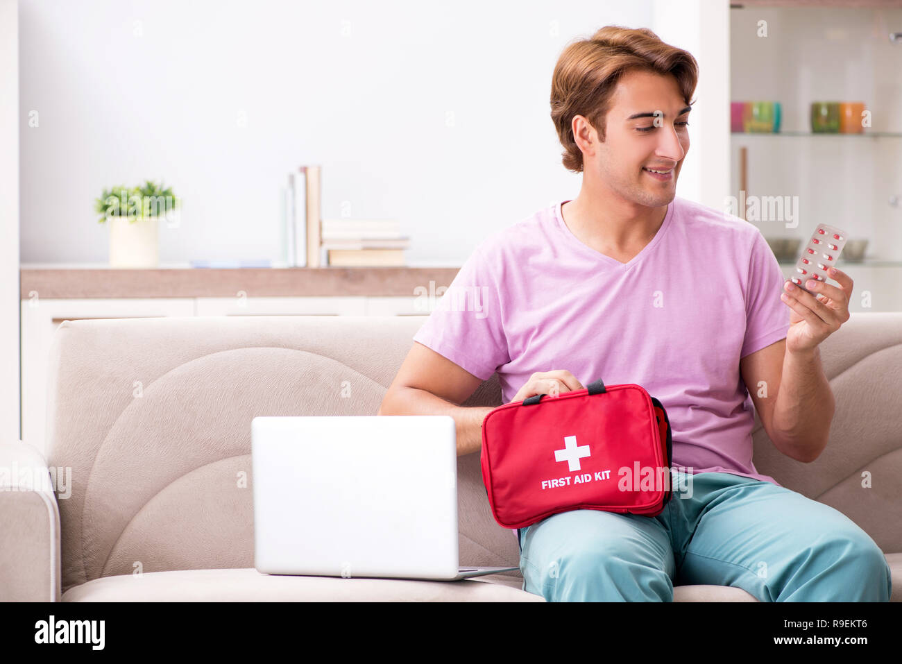Sick man at home with first aid kit Stock Photo - Alamy