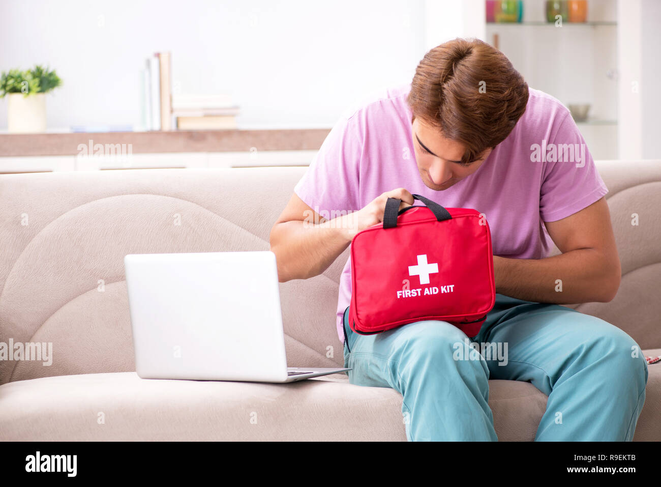 Sick man at home with first aid kit Stock Photo - Alamy