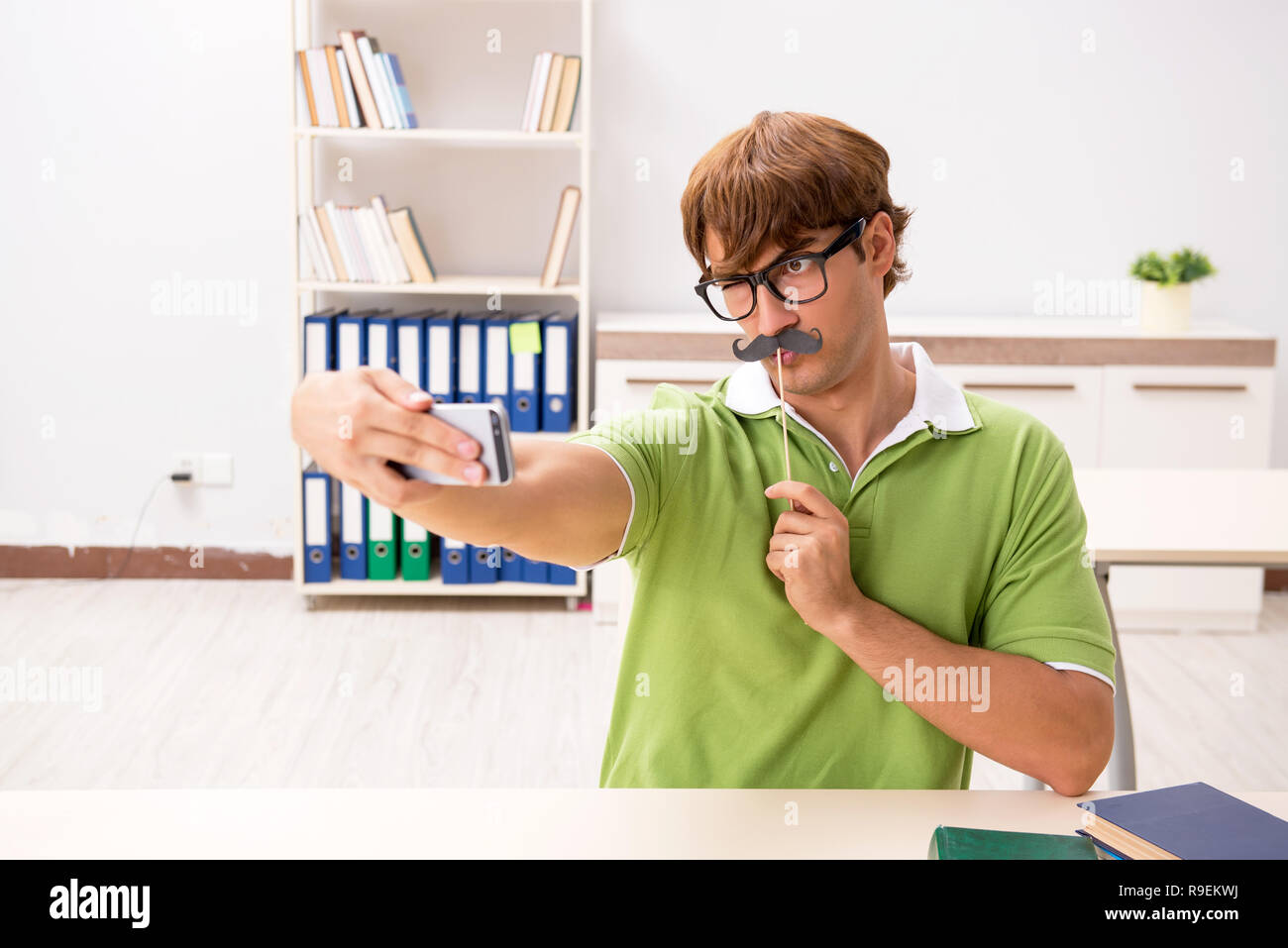Student with fake moustache reading book Stock Photo - Alamy