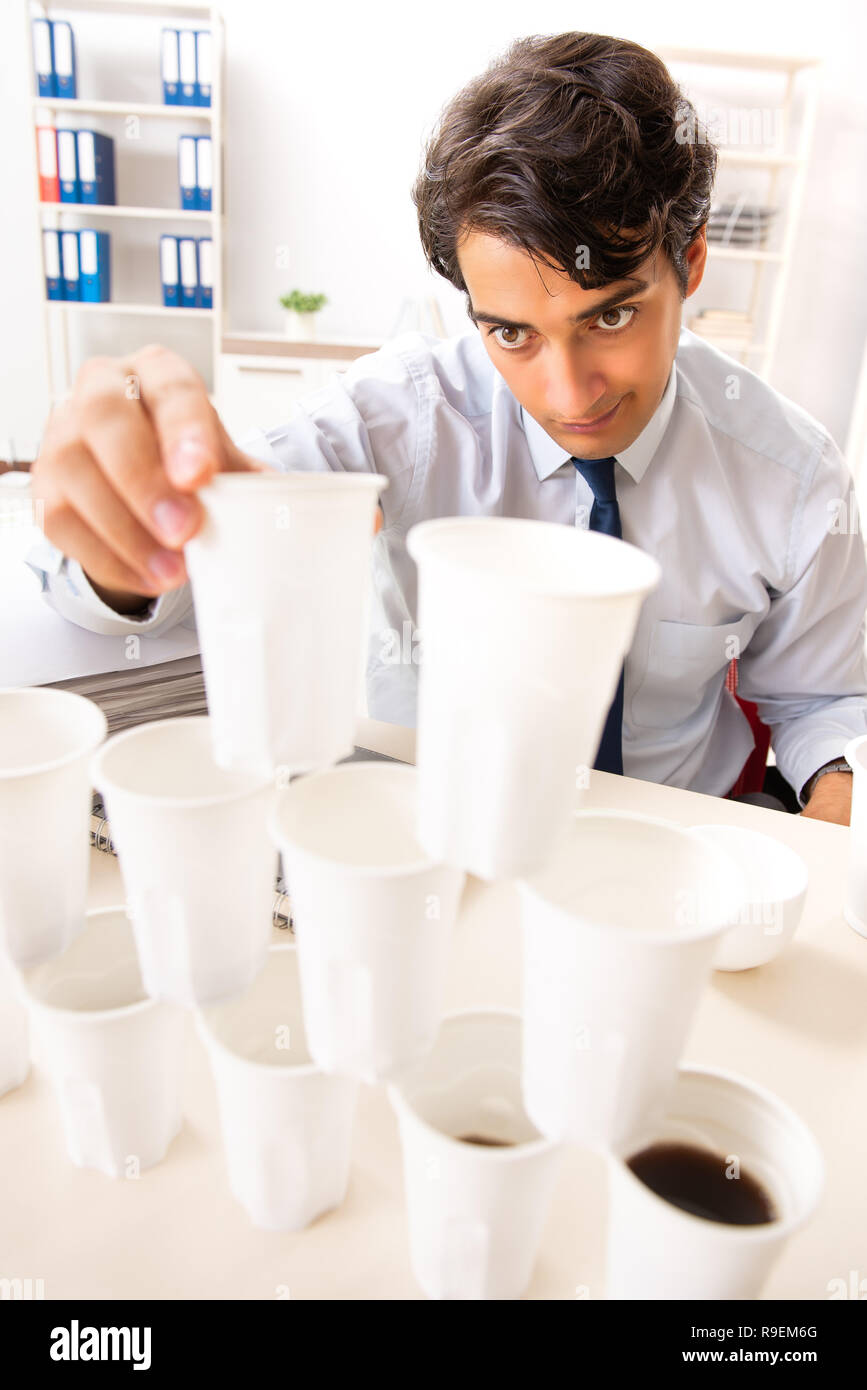 Young employee building pyramid from plastic cups Stock Photo - Alamy