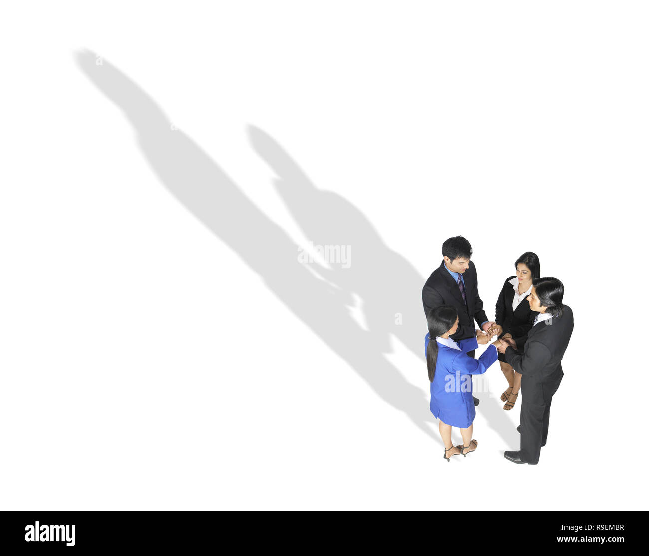 CORPORATE EXECUTIVES HOLDING HANDS AGAINST A WHITE BACKGROUND WITH LONG ...