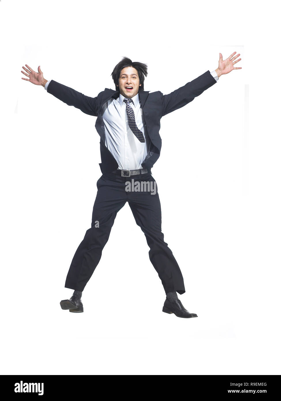 CORPORATE EXECUTIVE JUMPING IN EXUBERANCE WEARING A SUIT AGAINST A ...