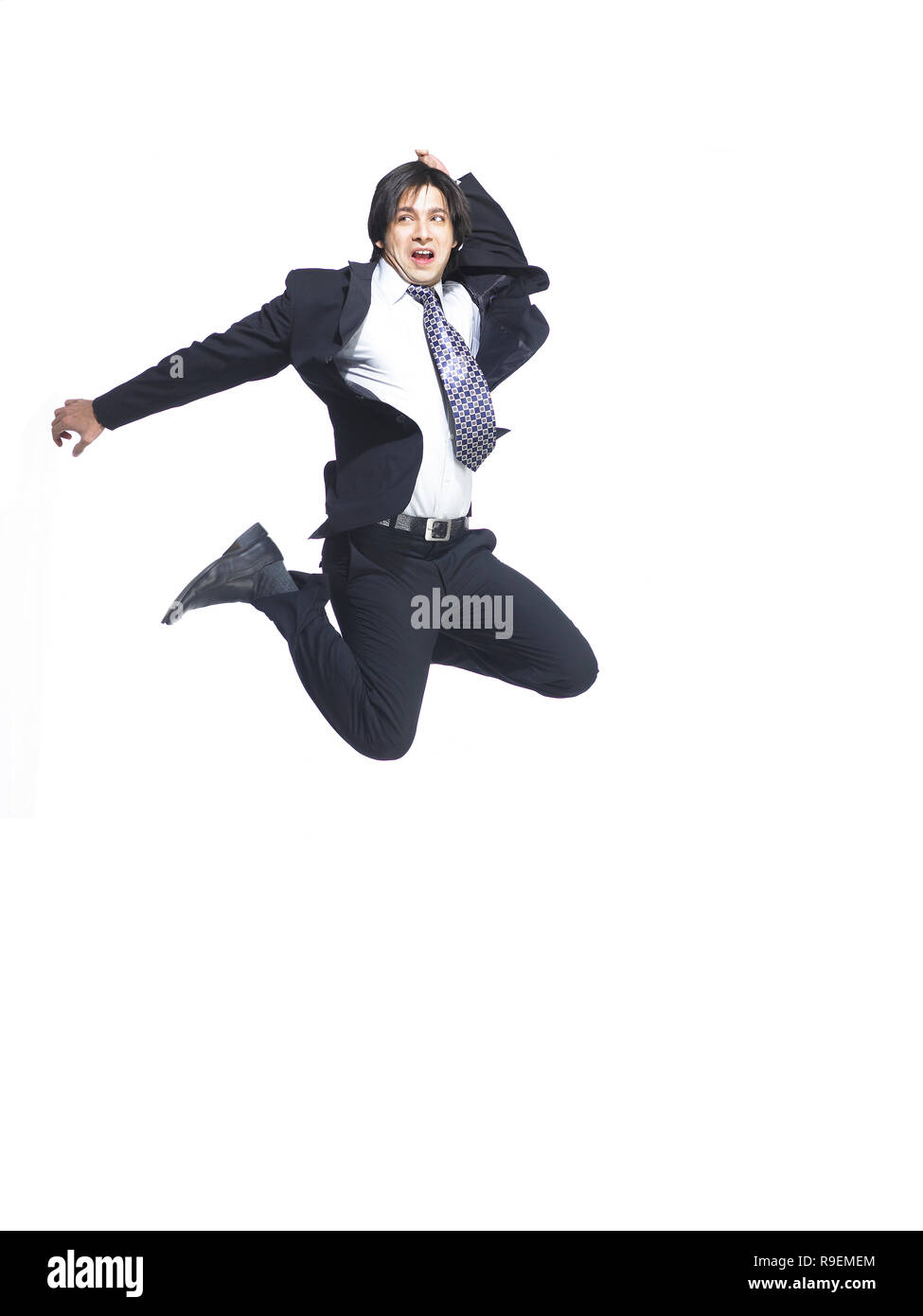 CORPORATE EXECUTIVE JUMPING IN EXUBERANCE WEARING A SUIT AGAINST A ...