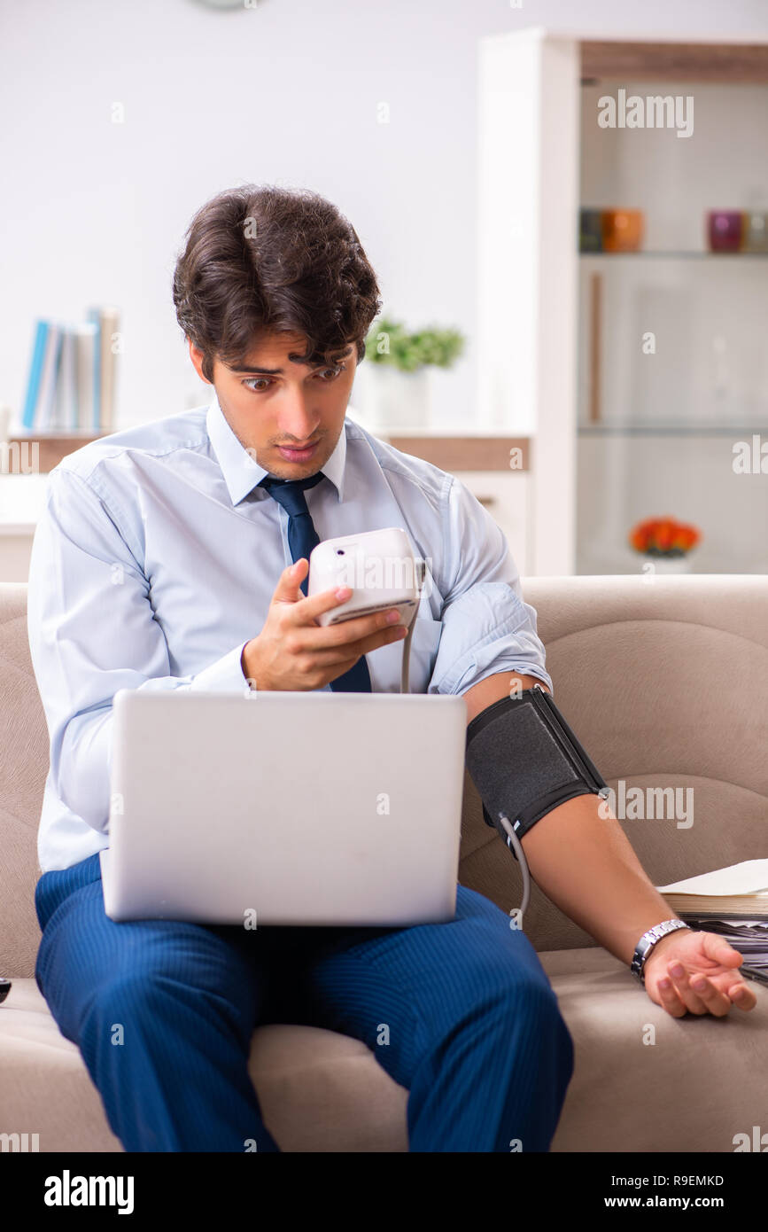 Man under stress measuring his blood pressure Stock Photo - Alamy