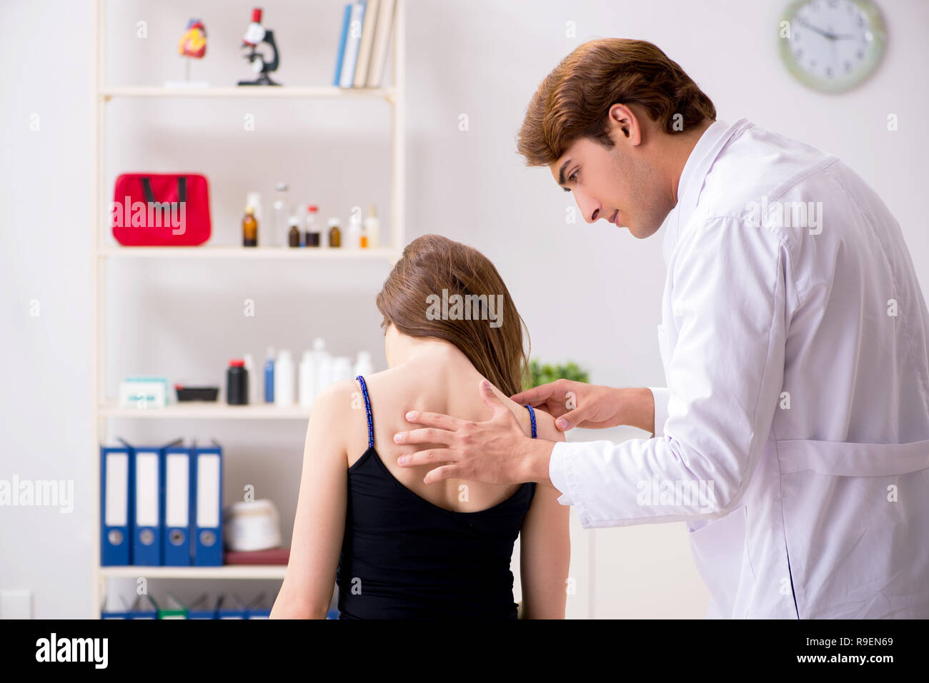 Female patient visiting young handsome doctor chiropractor Stock Photo ...