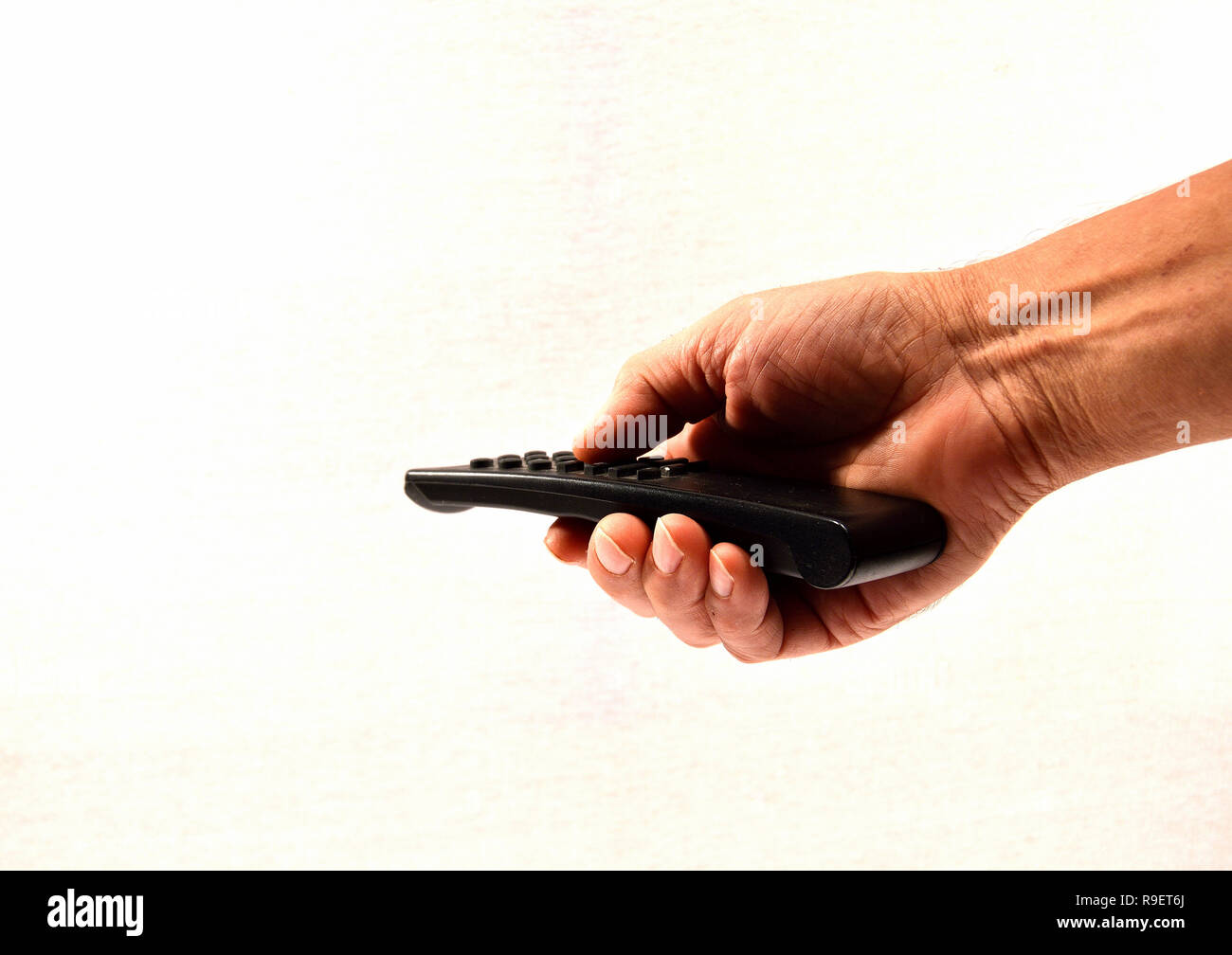TV remote in hand on a white background Stock Photo - Alamy