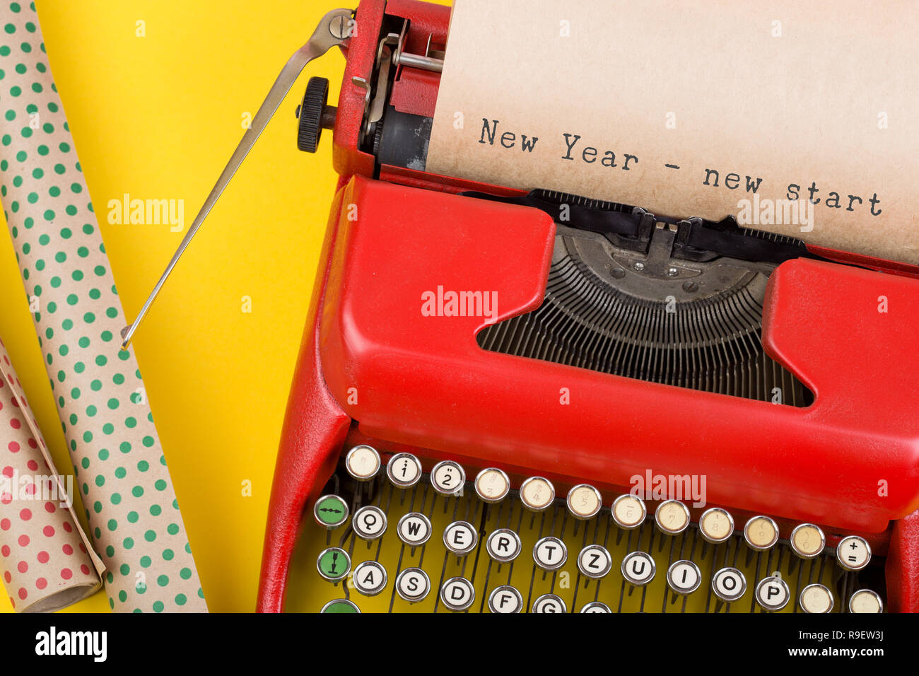 Holidays concept - red typewriter with text "New Year - new start" and ...
