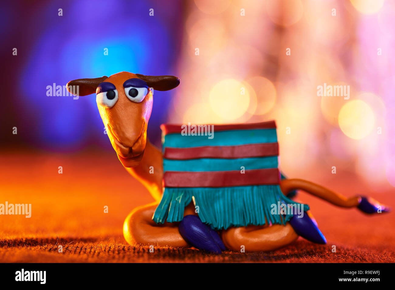 Fun orange plasticine Christmas camel on blurred background Stock Photo ...
