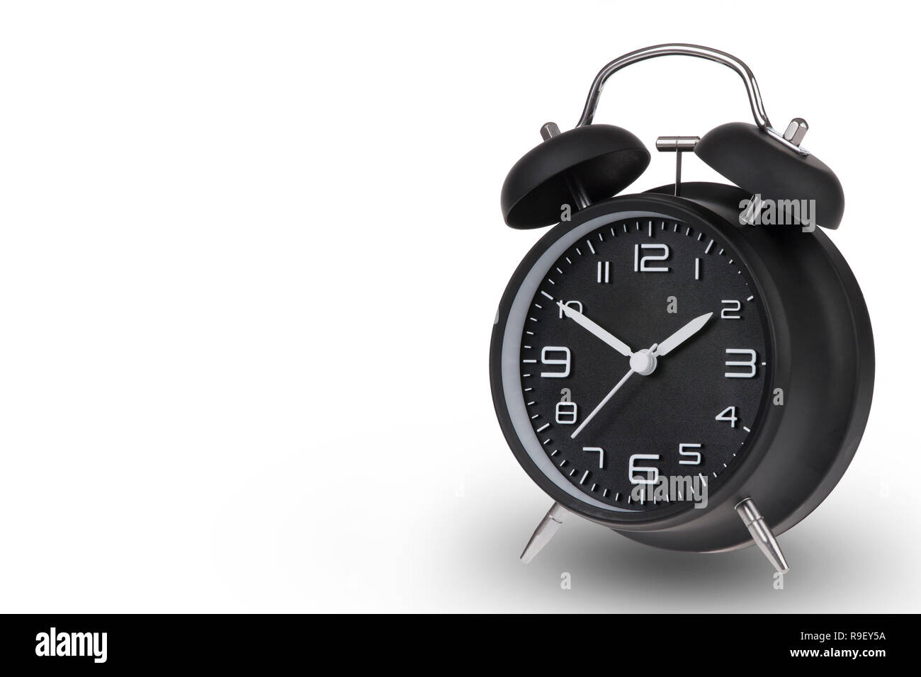 Black alarm clock with the hands at 10 and 2 am or pm isolated on a ...